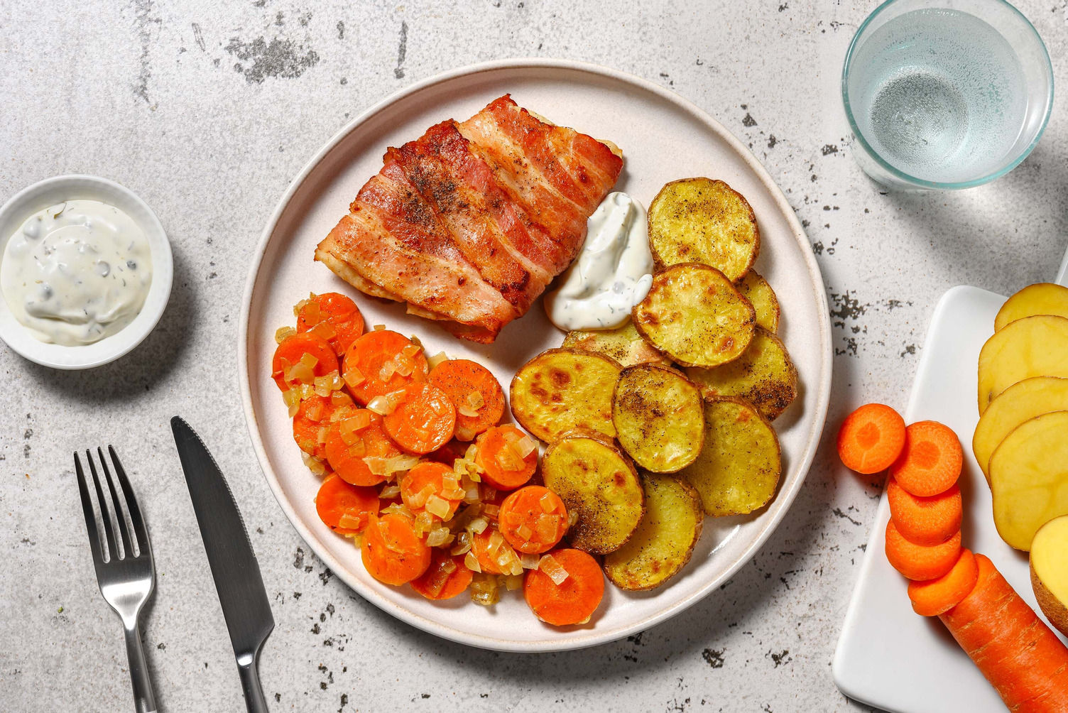 Pangasiusfilet in ontbijtspek met wortelschijfjes Recept | HelloFresh