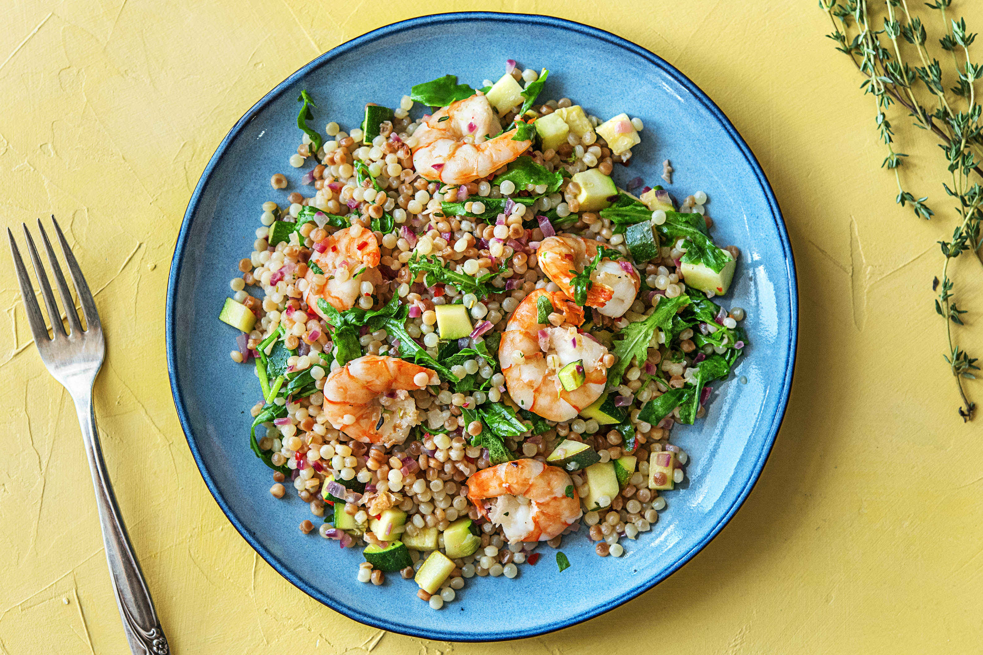 Parelcouscous met grote garnalen, courgette, verse tijm, rode peper en ...